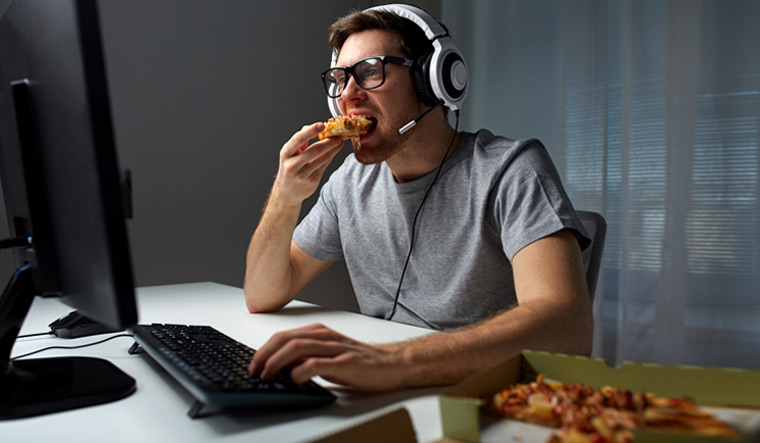 Playing games while eating may cut food intake: Study- The Week